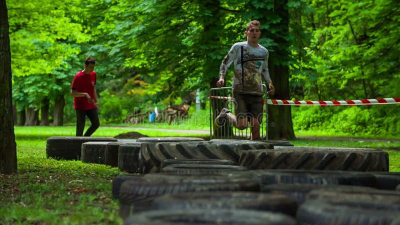 A Man Running with Tire in His Hand through Obstacle Course Stock Video ...