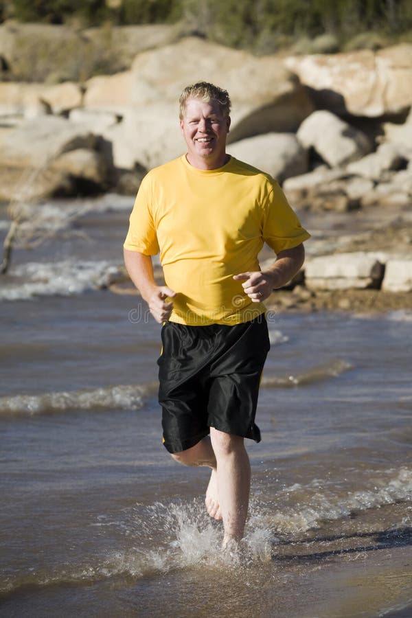 Man running in water stock photo. Image of smile, shorts - 11233610