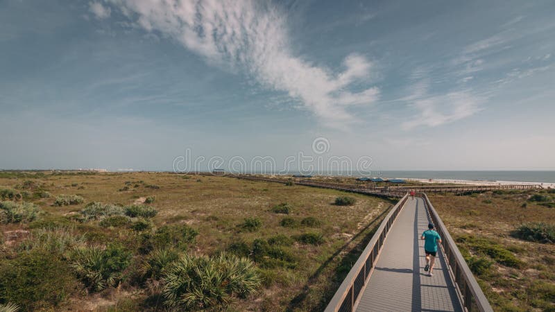 Aerial. a Man Runs on the Boardwalk at Smyrna Dunes Park on New Smyrna ... Aerial. a Man Runs on the Boardwalk at Smyrna Dunes Park on New Smyrna ...