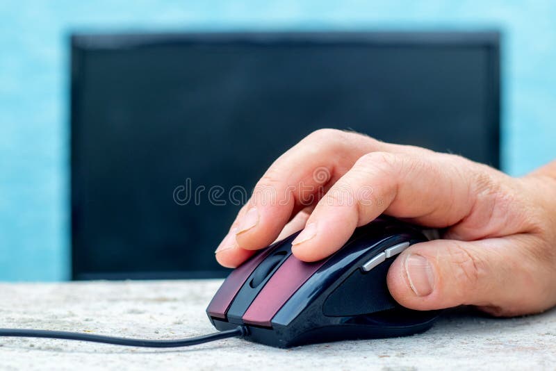 A Man`s Hand on a Computer Mouse Near a Computer. Entering Data on a ...