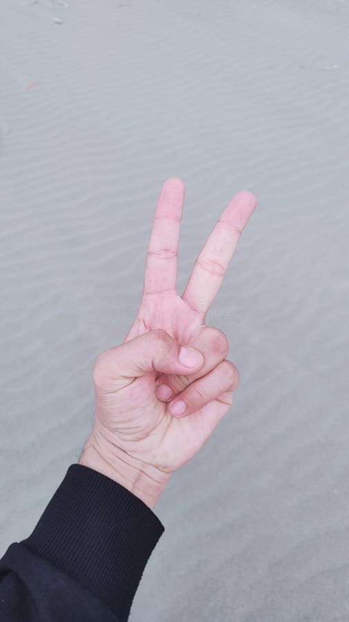A Man& X27;s Hand Gesturing Number Two with Sand Background Stock Image ...