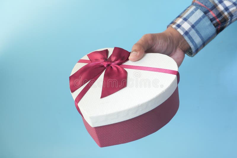 Man S Hand Holding a Gift Box on Blue Background Stock Photo - Image of ...