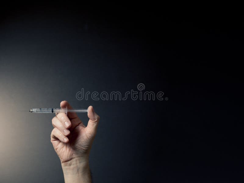 Man`s Hand Holding Syringe with Dramatic Lighting Stock Photo - Image ...