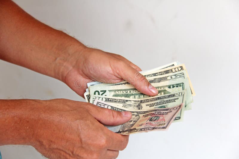The Man`s Hand Holds Us Dollars Counts Them And Pays Paper Mon Stock