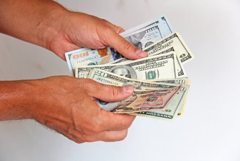The Man`s Hand Holds Us Dollars Counts Them And Pays Paper Mon Stock