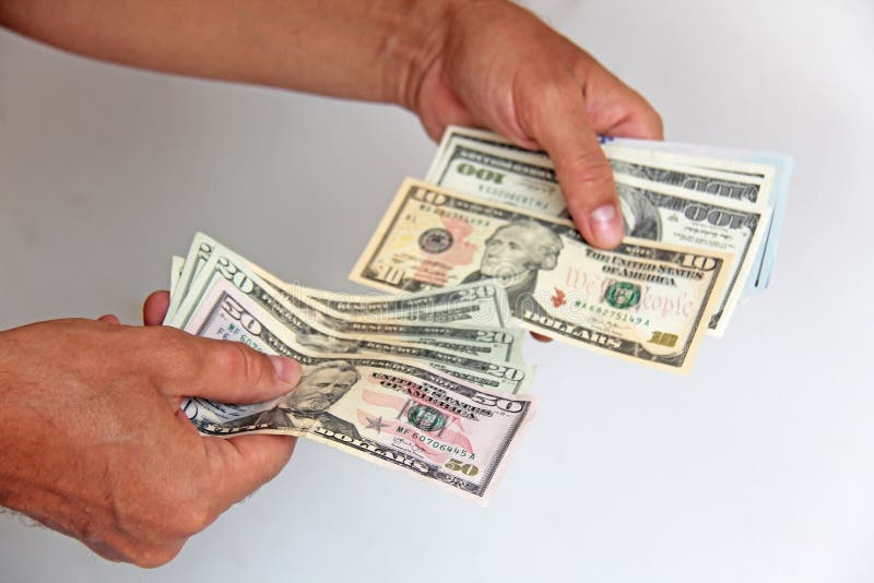 The Man`s Hand Holds Us Dollars Counts Them And Pays Paper Mon Stock