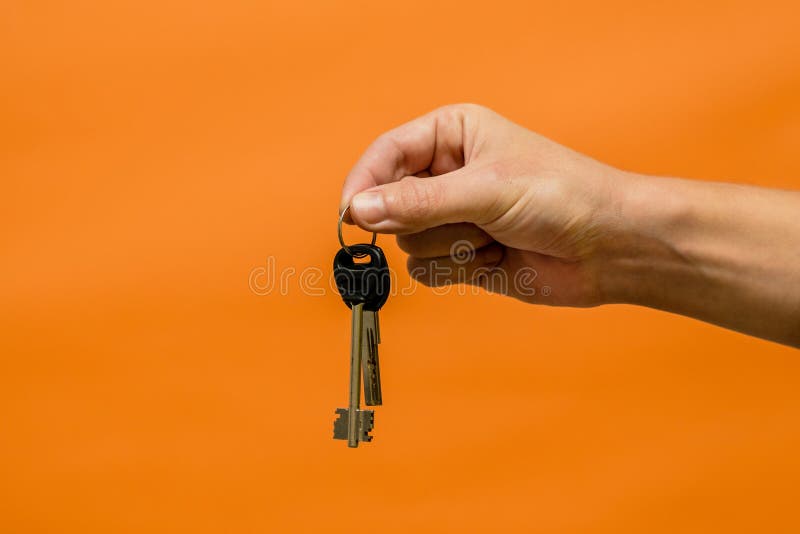Man S Hand with Keys Isolated on Orange Background Stock Photo - Image ...