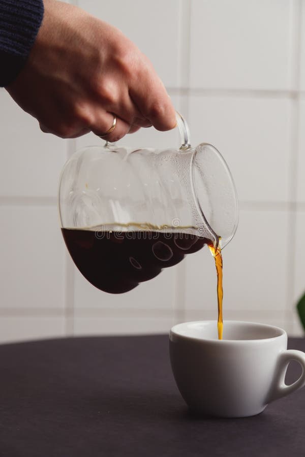 Man& X27;s Hand Pouring Coffee from Glass Coffee Pot into a White Cup ...
