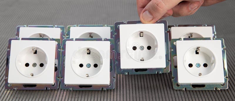 A Man& X27;s Hand Puts an Electric Socket in a Row. the Concept of ...