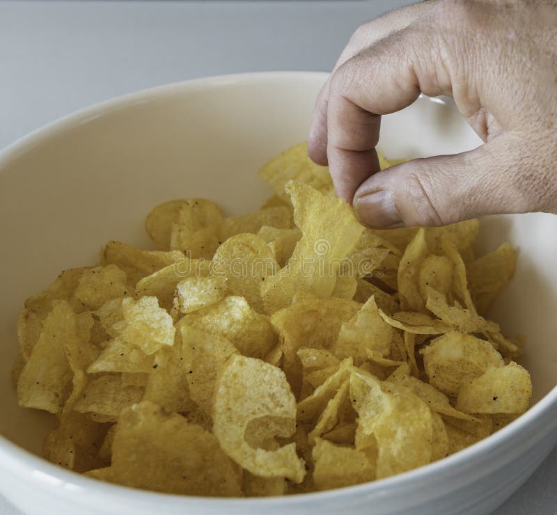 A Man S Hand Reaching Potato Chips in White Ceramic Bowl Stock Image ...
