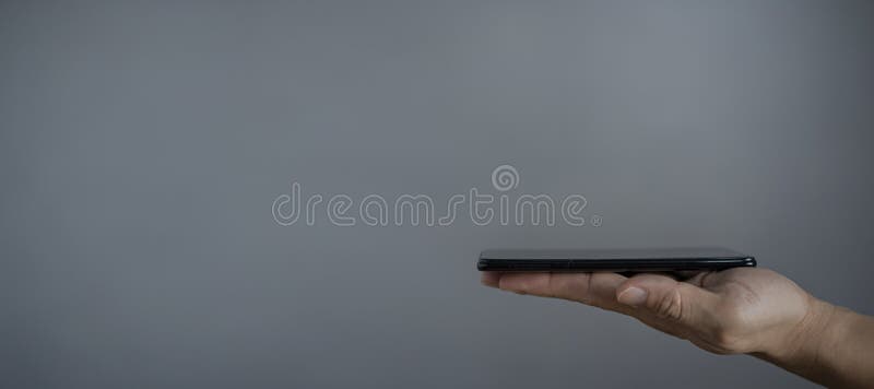 Man`s Hand with Smartphone Screen Facing Up Isolated on Dark Gray ...
