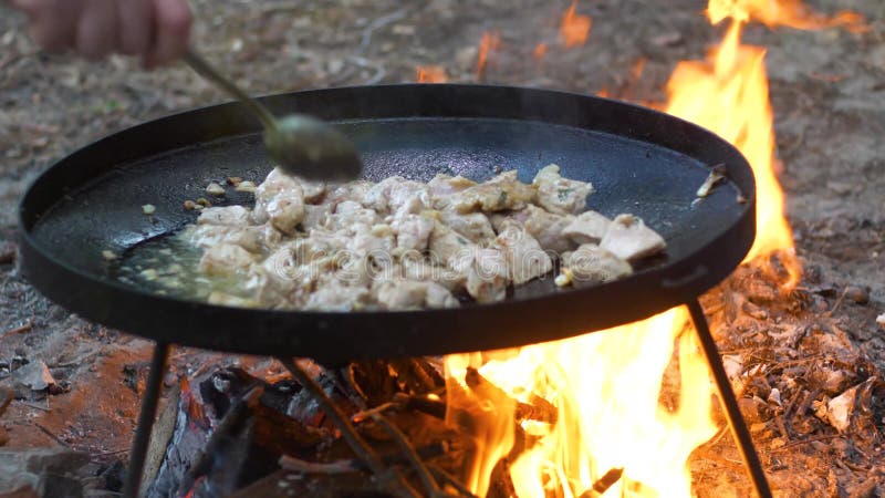 A Man S Hand Stirs Meat with a Spoon in a Frying Pan, Which is on a ...
