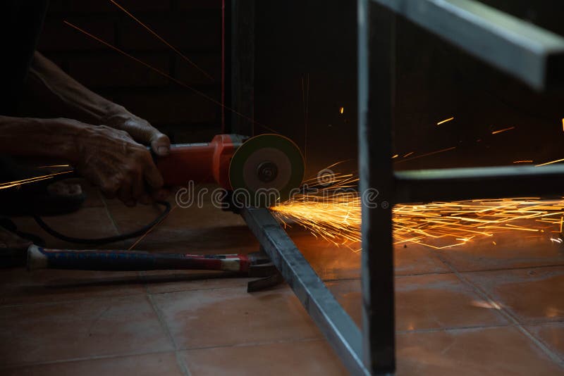 A Man`s Hand is Using a Steel Cutter To Make a Spark Table Structure ...