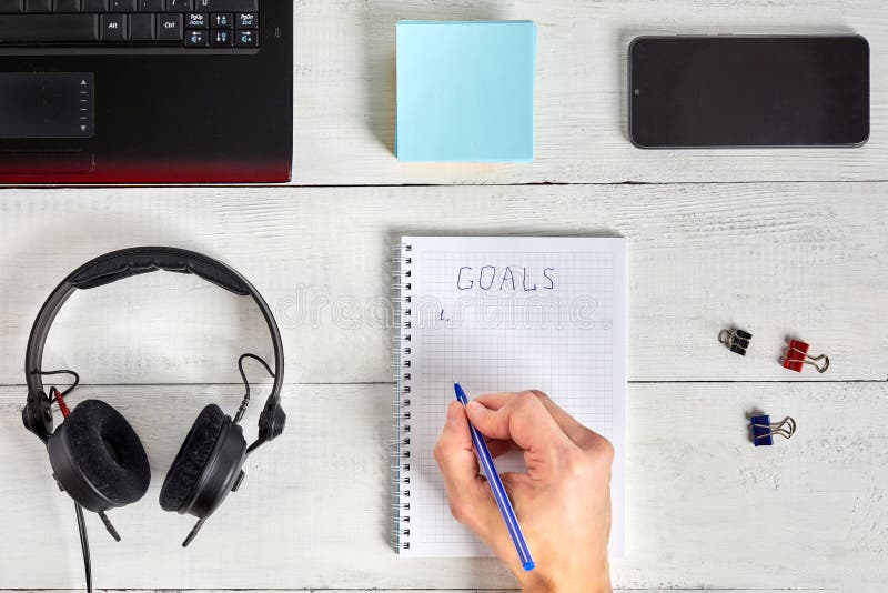 Man`s Hand Writing in Notebook on White Wooden Table. Working Place and ...