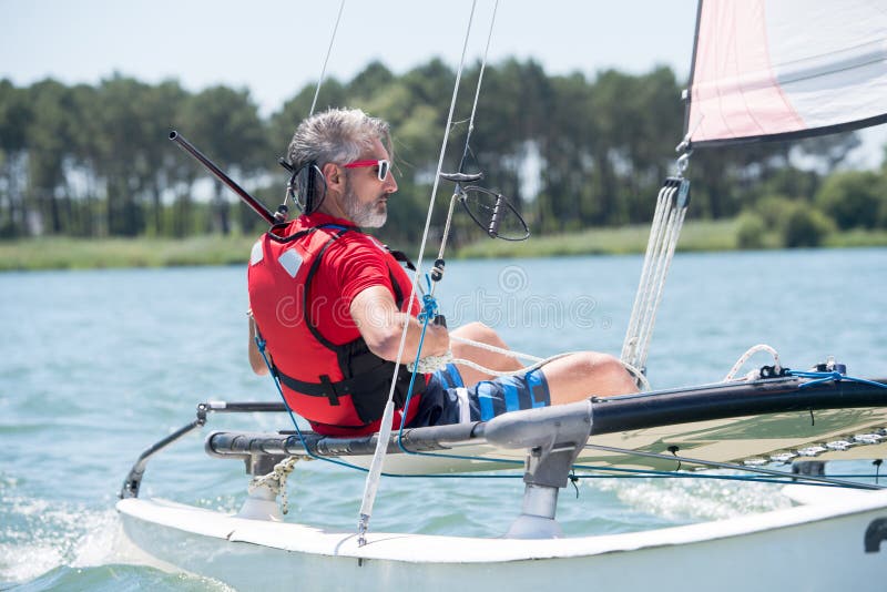Man Sailing with Sails Out on Sunny Day Stock Photo - Image of ...