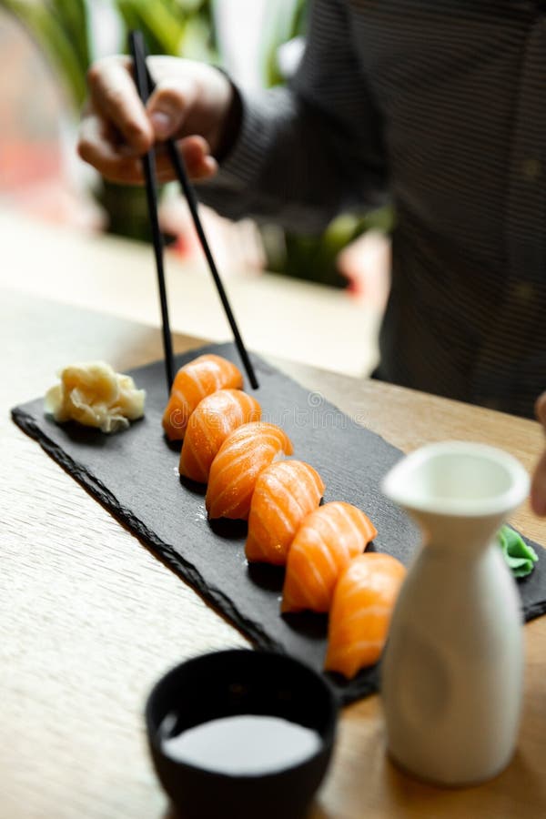 Man Salmon Sushi on Restaurant Table. Asian Man Eating Salmon Sushi Set ...