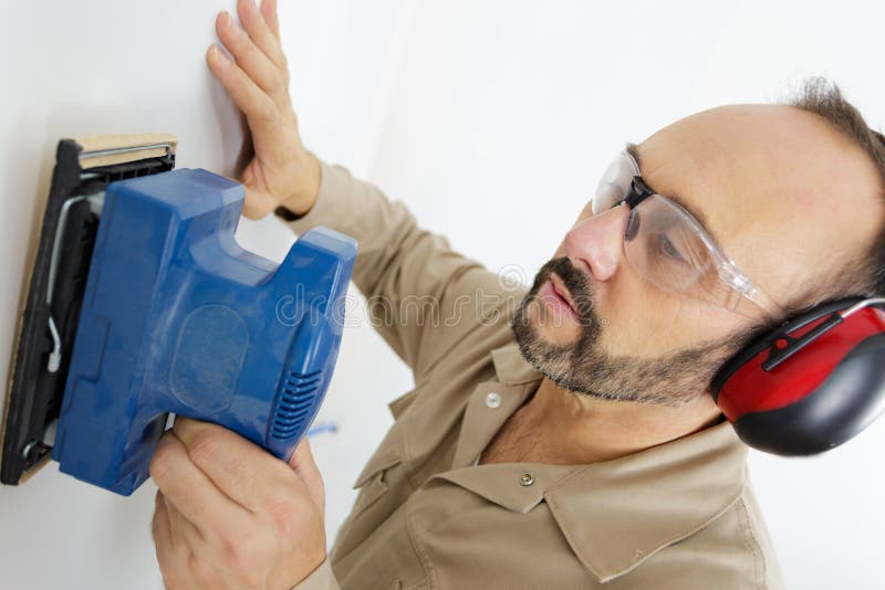 Man sanding wall stock photo. Image of construction - 160148306