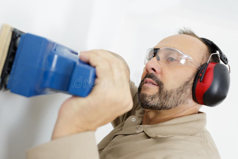 Man sanding wall stock image. Image of sandpaper, surface - 196545657