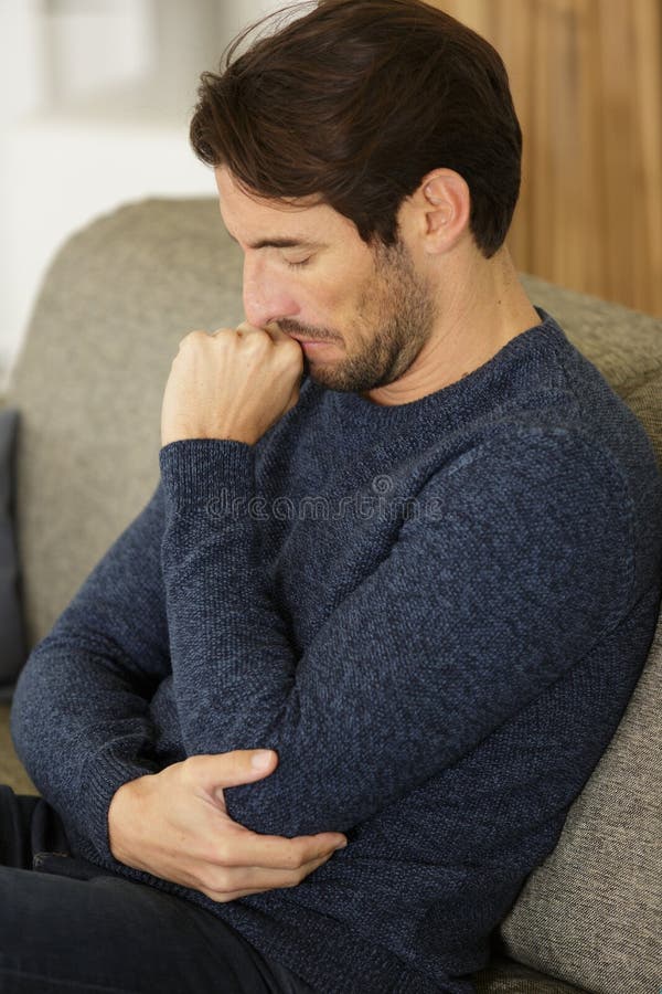 Man Sat Alone on Sofa Holding Back Tears Stock Photo - Image of ...