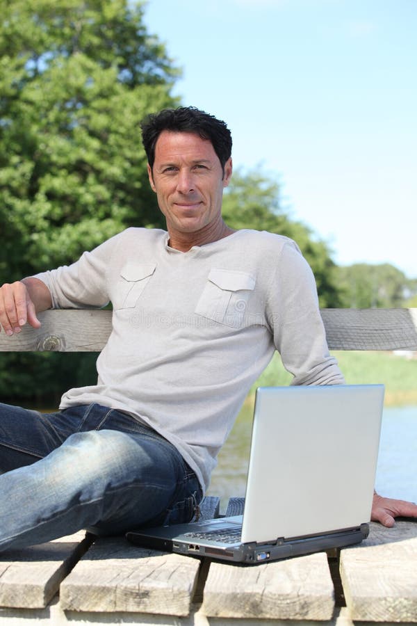 Man sat on park bench stock photo. Image of field, laptop - 25667114