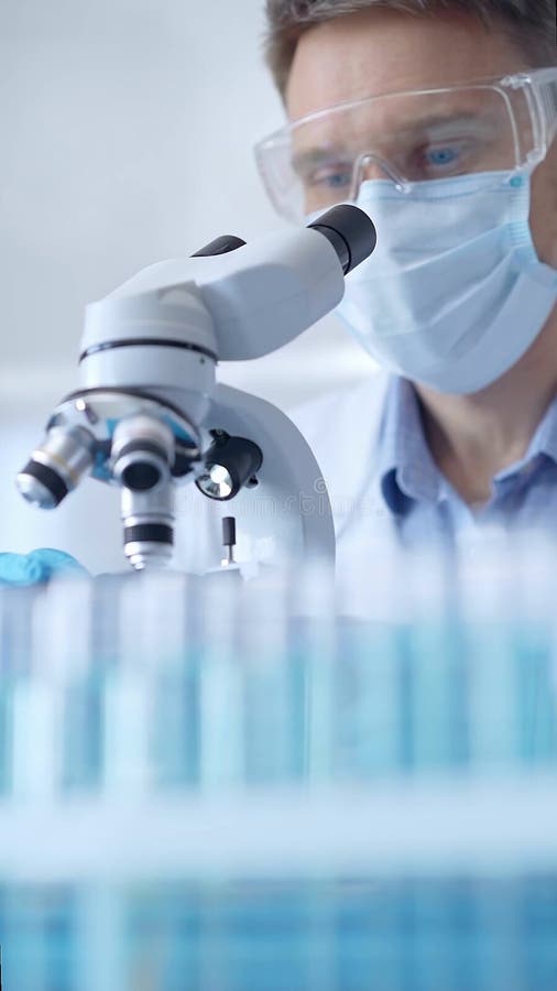 Man Scientist with Protective Glasses, Mask and Gloves is Using ...