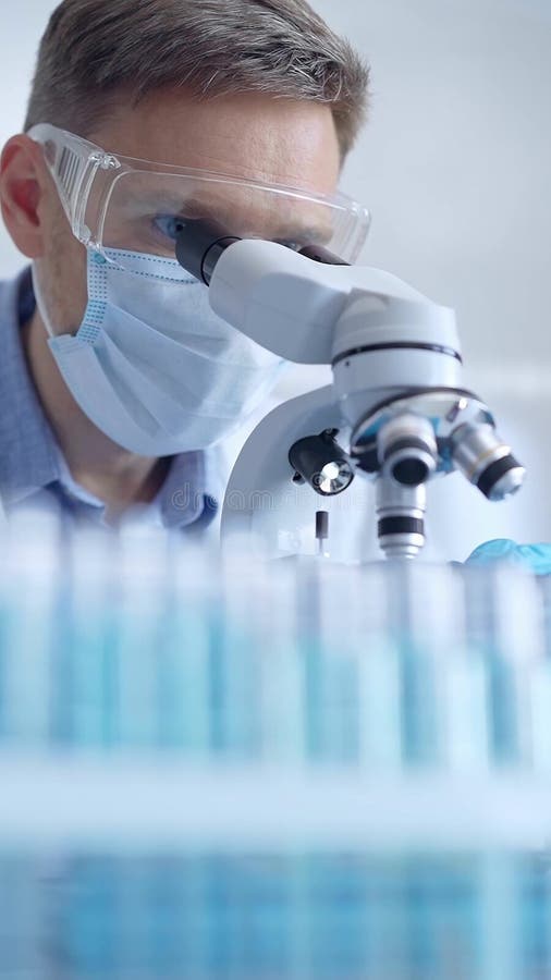 Man Scientist with Protective Glasses, Mask and Gloves is Using ...