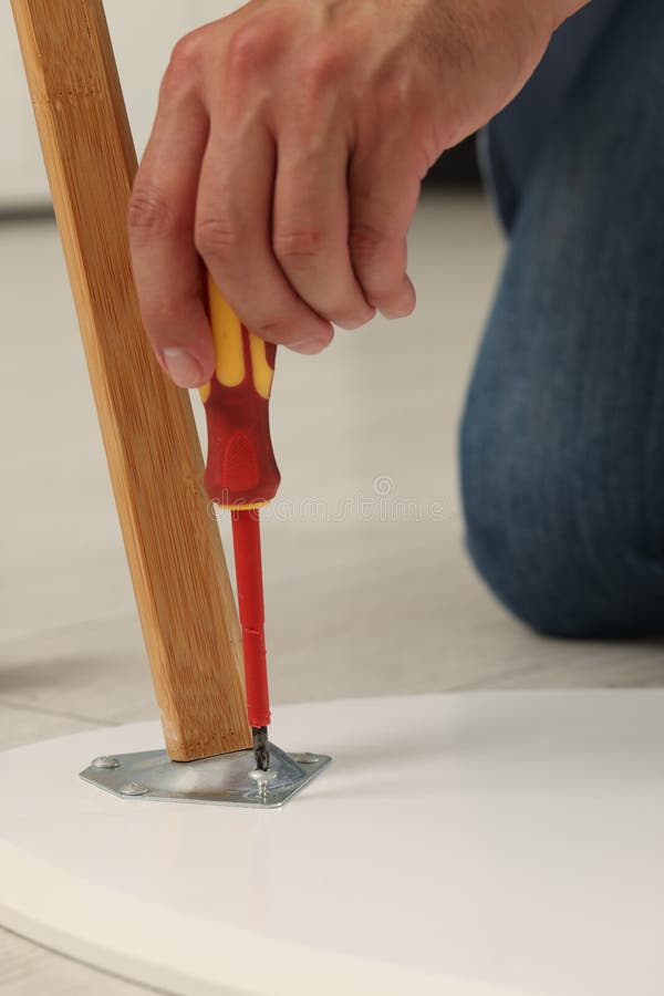 Man with Screwdriver Assembling Table on Floor Indoors, Closeup Stock ...