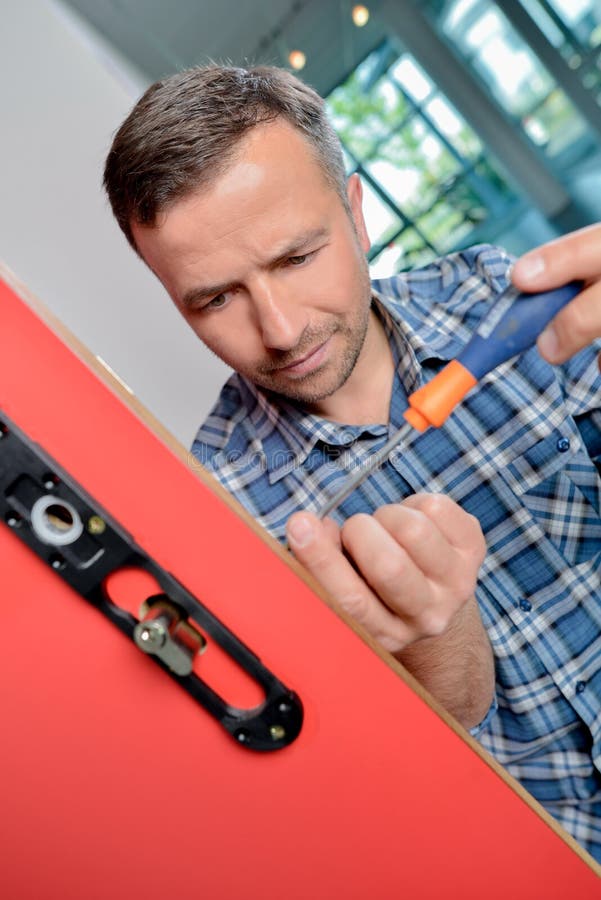 Man screwing door lock stock image. Image of locks, building - 95598167