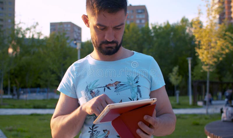 Man Scrolling the Tablet in the Park Stock Photo - Image of human ...