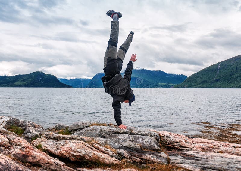 Man Sdand on One Hand on the Rock Stock Image - Image of standing ...