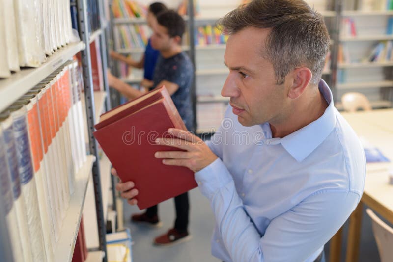 Man Searching for Book in Library Stock Photo - Image of world, culture ...