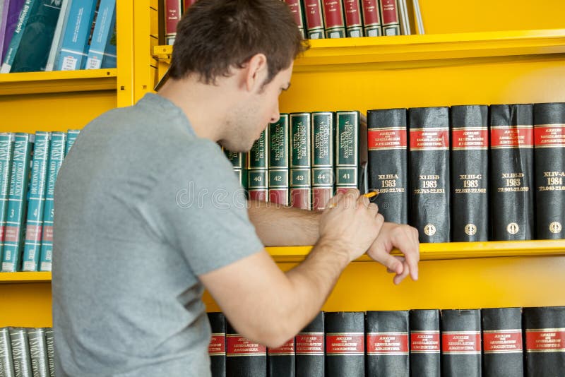 Man searching a book stock photo. Image of indoors, arms - 73373516