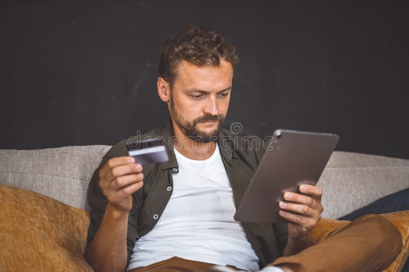 Man Sitting on Couch with Tablet and Credit Card Stock Photo - Image of ...
