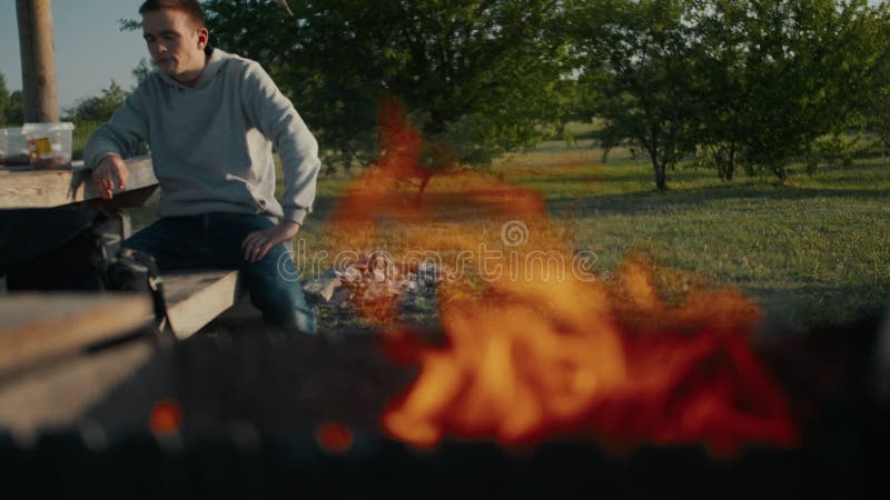 A Man is Seated Outdoors at a Table, Enjoying a Meal while Facing a ...