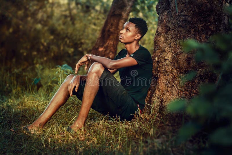 Man Seating Beside Tree Trunk Picture. Image: 114751032