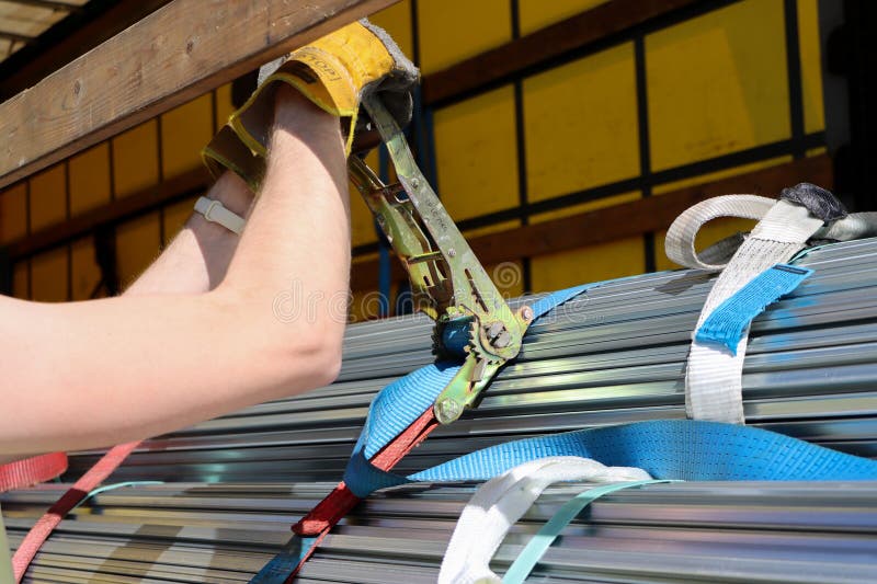 A Man Secures a Load with a Lashing Strap Stock Photo - Image of metal ...