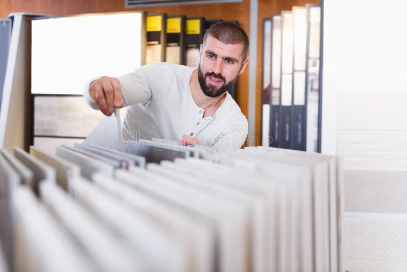 Man selecting ceramic tile stock image. Image of modern - 223333463