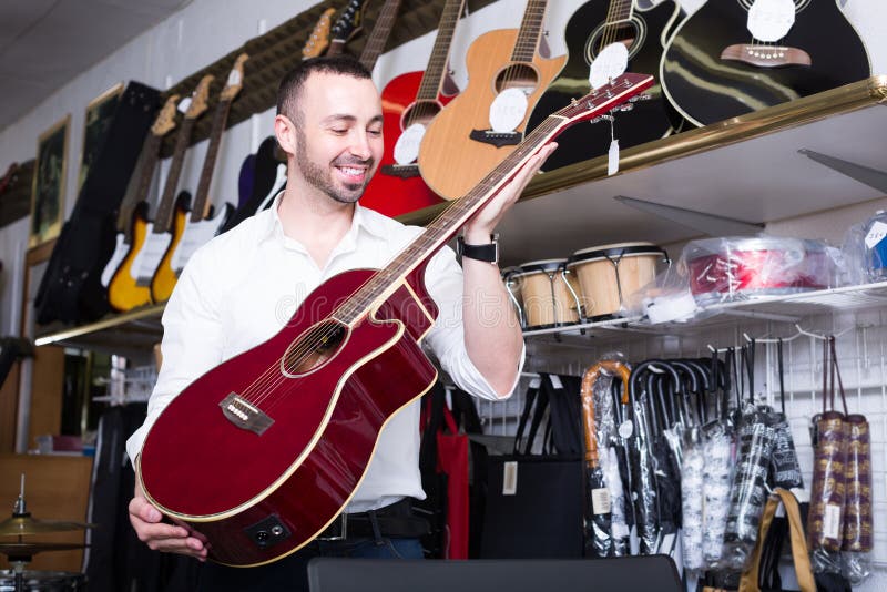 Man Selecting Classical Guitar Stock Photo - Image of professional ...