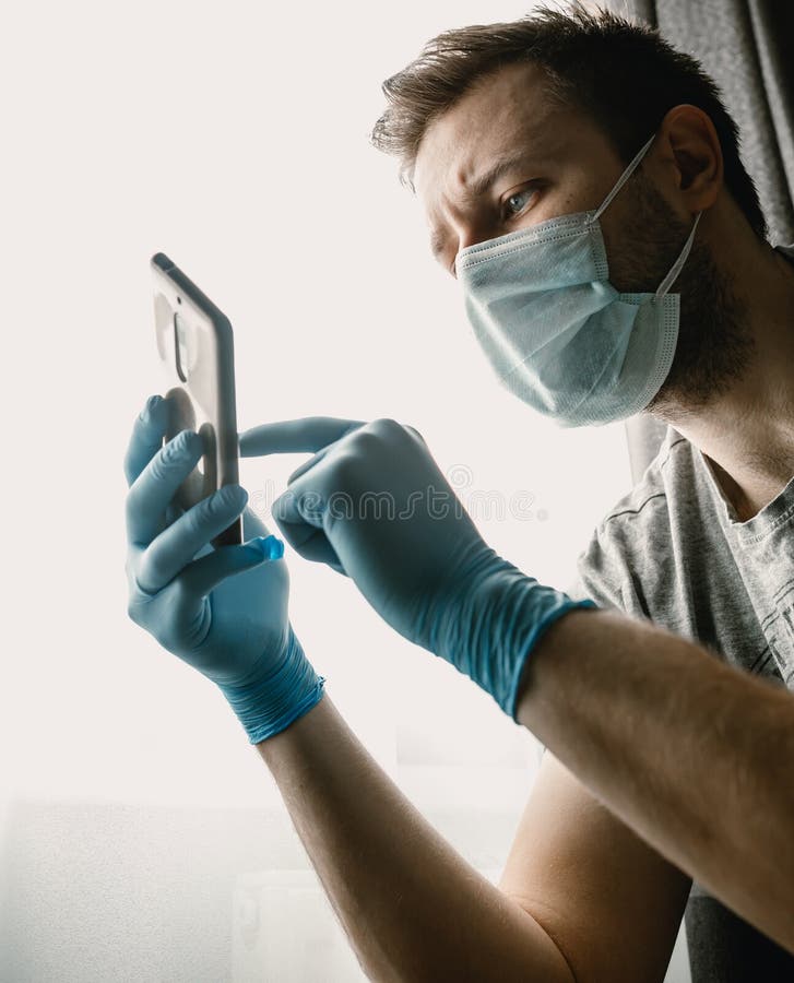 Man on Self-isolation, Quarantine at Home. Looks at the Phone Stock ...