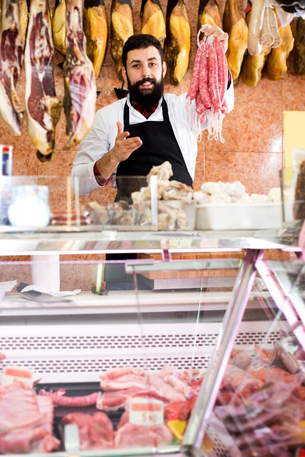 Man seller in butcher shop stock photo. Image of choosing - 234558800
