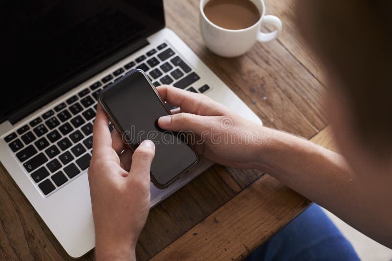 Man Sending Text Message on Mobile Phone Whilst Using Laptop Stock ...