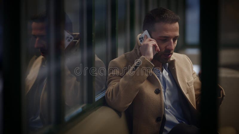 A Man is on a Serious Phone Call in Public Transport, Reflecting on ...