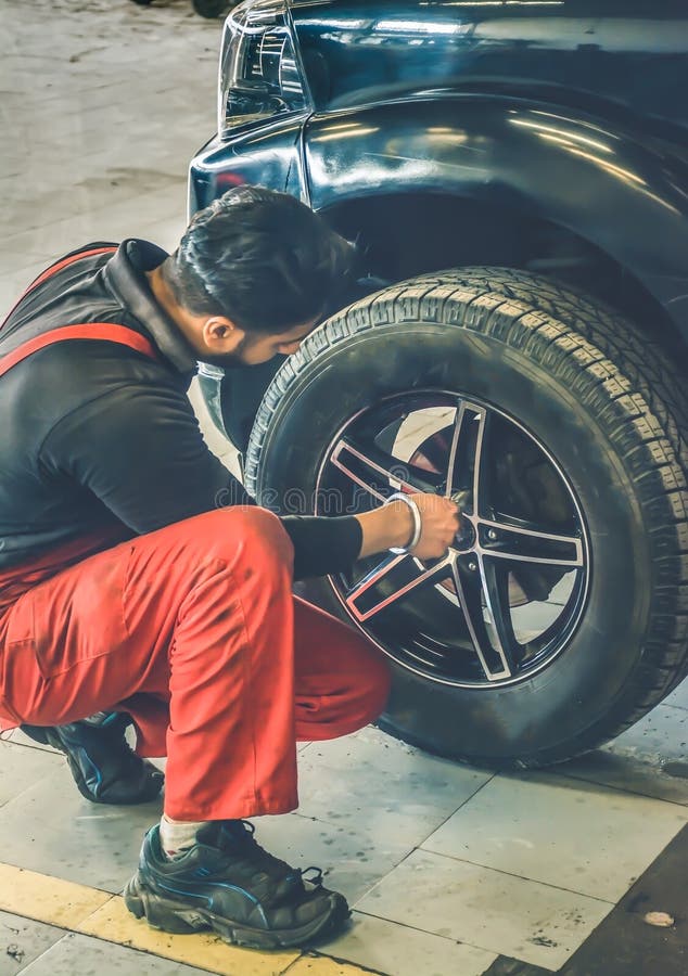 Man Servicing Car and Opening the Tyre of the Car Editorial Photo ...