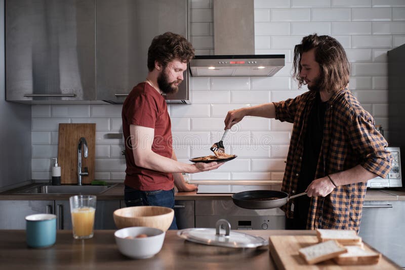Man Serving Friend Toasts from the Pan Stock Photo - Image of happy ...