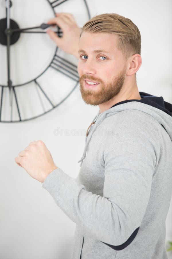 Man Setting Time on Wall Clock Stock Photo - Image of casual, reset ...