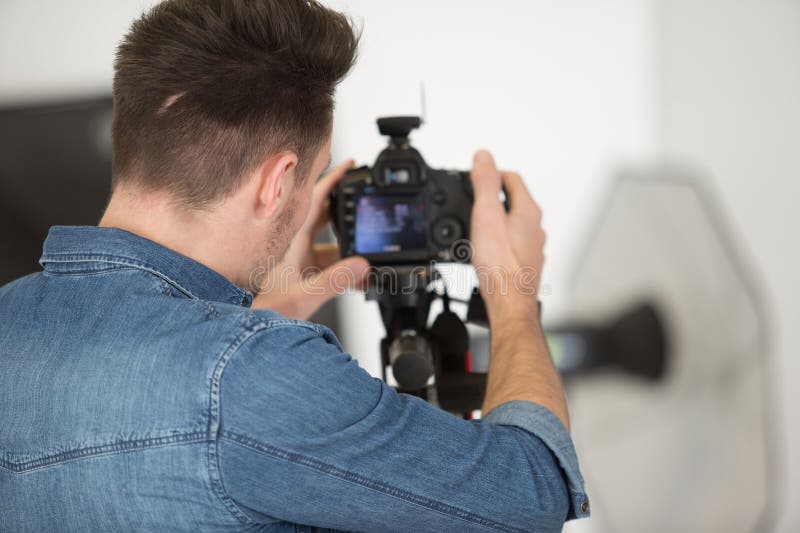 Man Setting Up Camera on Tripod Stock Image - Image of studio, taking ...