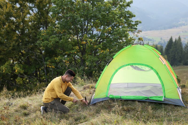 Man Setting Up Camping Tent on Hill Stock Photo - Image of gear, hill ...
