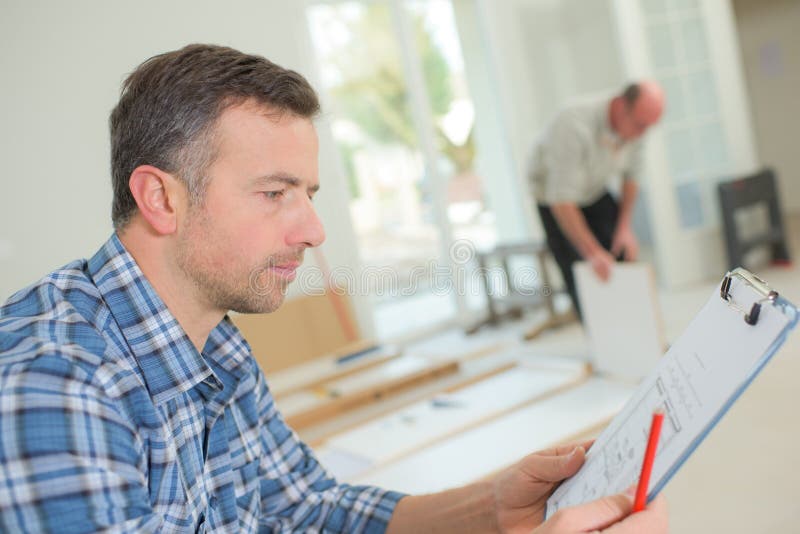 Man setting up furniture stock photo. Image of furniture - 249435850