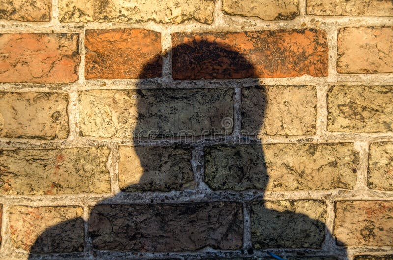 Man shadow on a brick wall stock image. Image of urban - 267363507