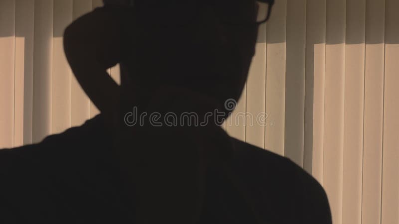 Talking from a Shadow in Front of a Bald Man in a Blue Shirt on a Green ...